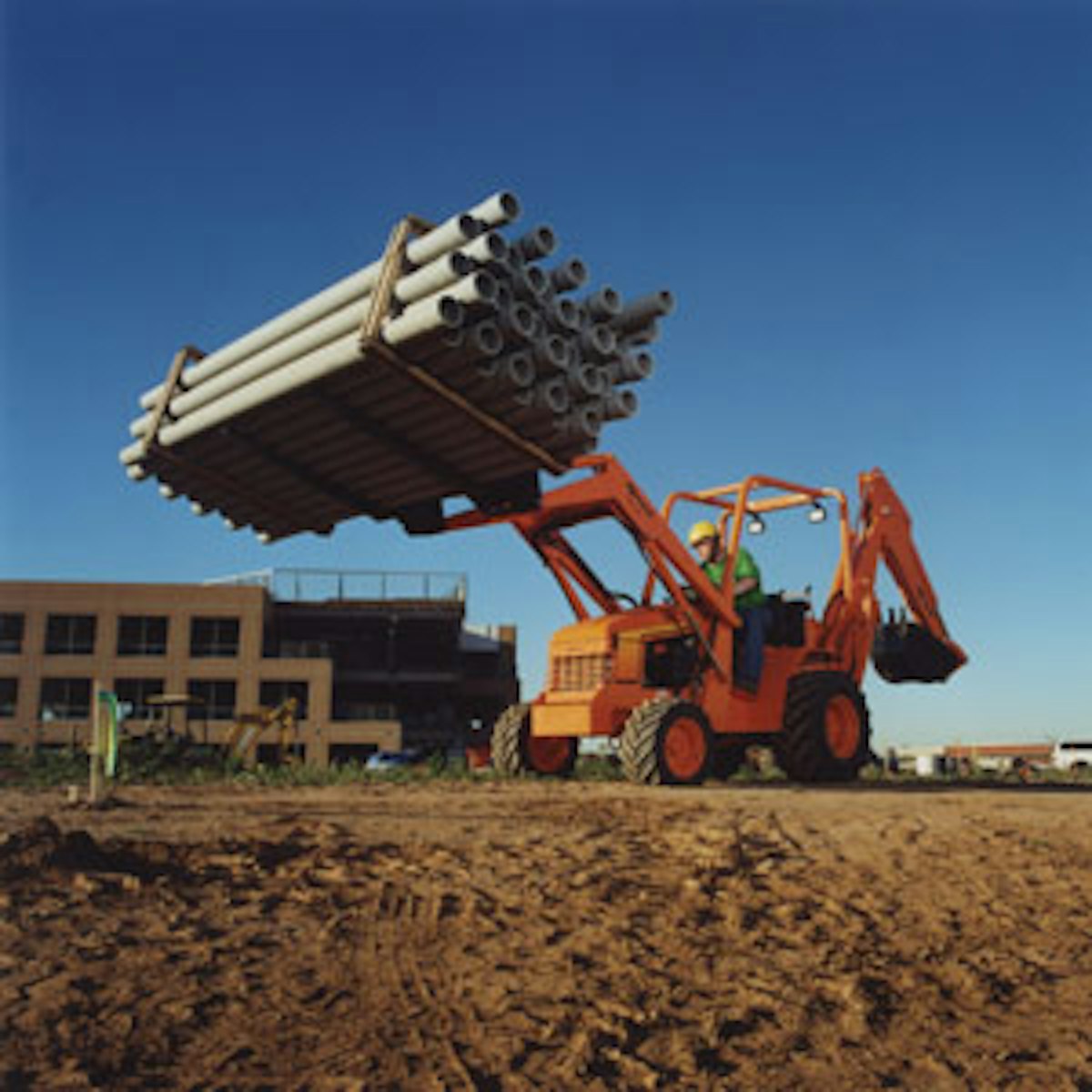 Tractor-loader-backhoes (TLBs) show they are construction equipment ...